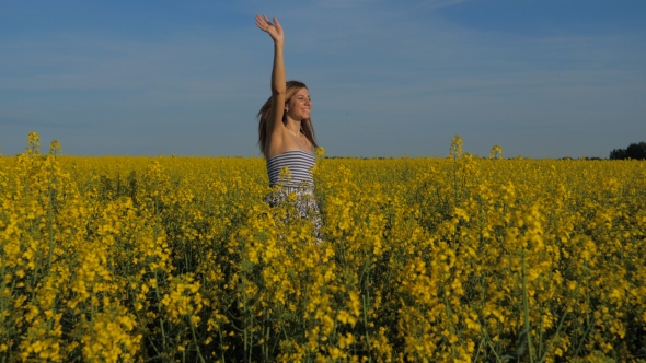 Happy Girl Running Through Field of Yellow Flowers and Waving Hands ...