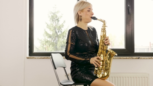 Beautiful Saxophonist Woman Playing at the Sax in the Living Room ...