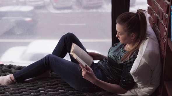 Young Pensive Woman Reading Book on Bed By Window Overlooking City ...