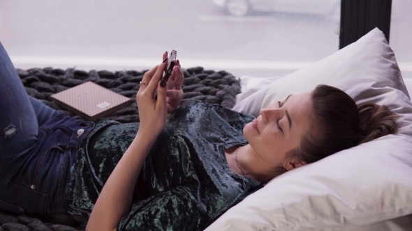 Young Female Using Smartphone on Bed By Window, Stock Footage | VideoHive