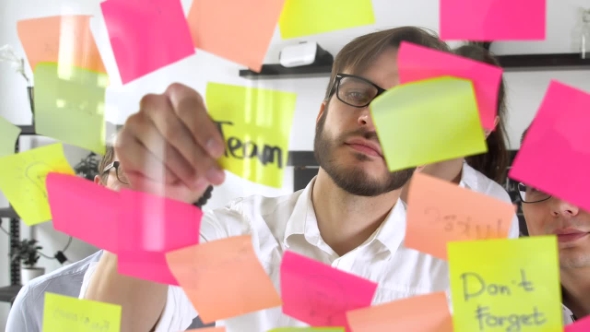 Man Post in Sticky Note While Meeting in Office on the Sticker Is ...