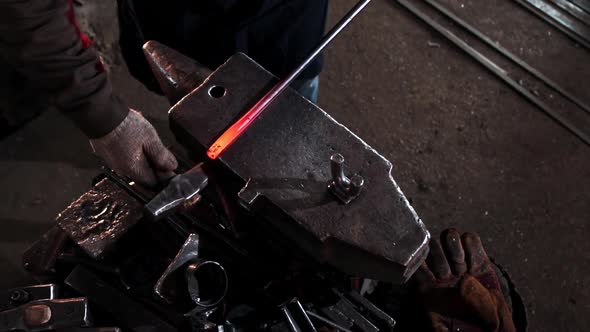 Blacksmith Bends an Oblong Red Heated Metal Detail By Hitting in with a ...