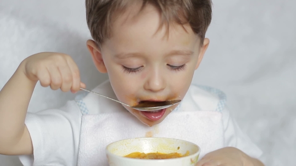 The Child Boy with Pleasure Eat Soup From Dishes with a Spoon. Motion ...