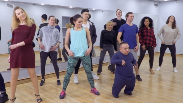 Young Group of People and Little Man Dances Together in Light Studio ...