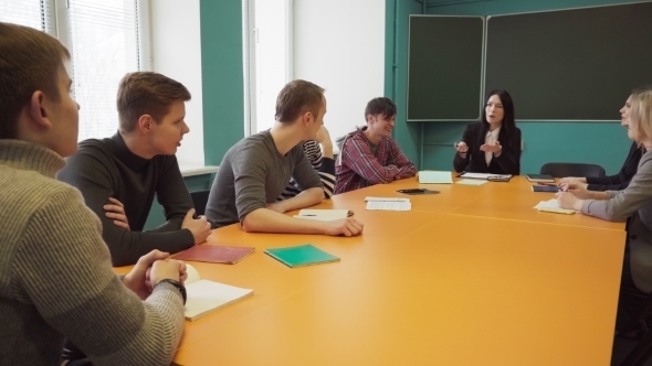 Group of Students and a Teacher Sit at a Table and Talk, Stock Footage