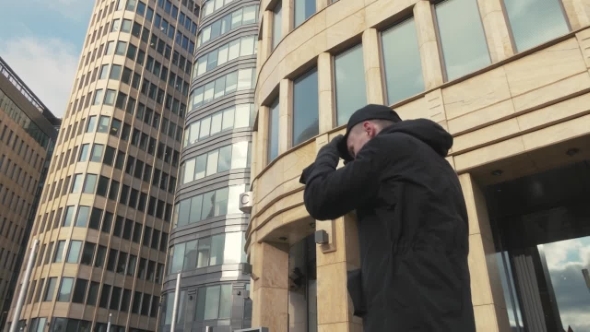 Man in Black Cap Walking on City Street and Waving Hand for Greetings ...