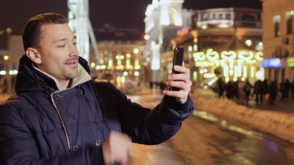 Young Guy Talks with Friend on the Video Call at Night City Background ...