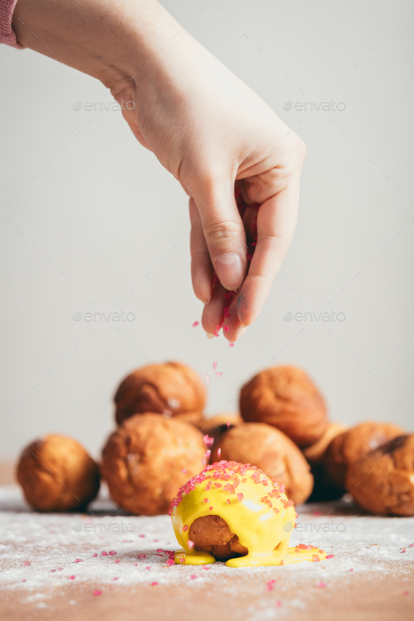 Sprinkling sugar topping on top of a doughnut. Stock Photo by photocreo