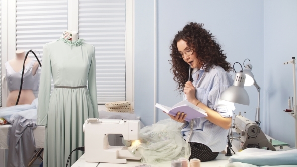 Female Tailor Writing The Length and Width of Fabric in Notebook ...
