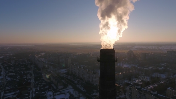 Aerial Shot of High Tube with White Flame Looking Smoke in Snowy City ...