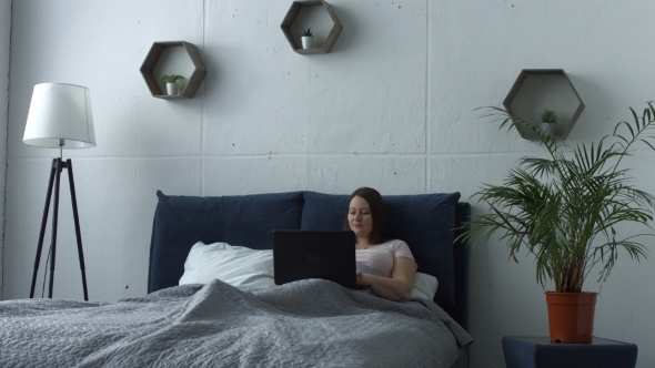 Woman Working on Laptop While Relaxing in Bed, Stock Footage | VideoHive