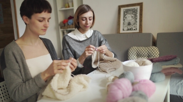 Smiling Woman Knitting and Talking at Work Table in Creative Studio ...