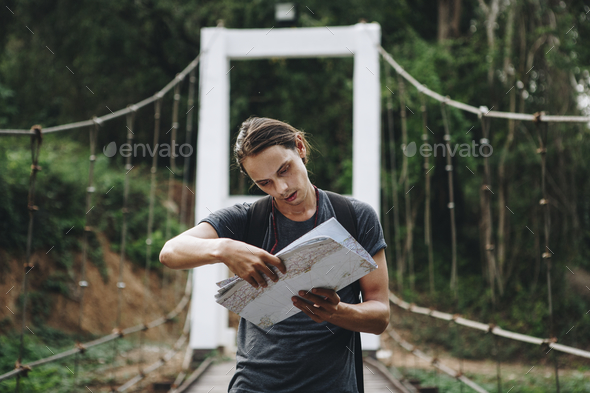 Confused Caucasian man looking at a map travel and explore concept ...