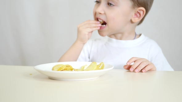 Child Boy Eating Potato Chips on a White Background, Stock Footage
