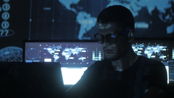 Hacker Programmer in Glasses Is Working on Computer While Blue Binary ...