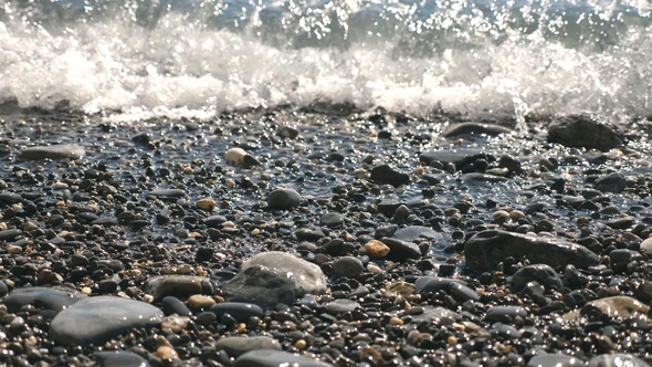 Calming Scene of Gentle Waves Splashing To Pebble Beach on Sunny Day, Stock Footage