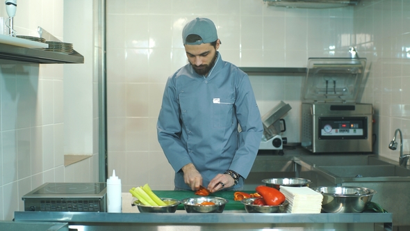 The Chef in Blue Apron Cuts Pepper, Stock Footage | VideoHive