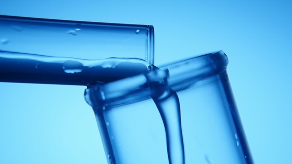 Blue Water Flows From a Narrow Tube Into a Wide One in a Scientific Lab ...