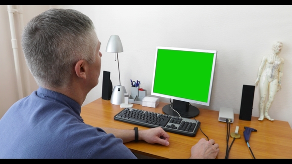 Doctor Sits at the Computer with a Green Screen, Stock Footage | VideoHive