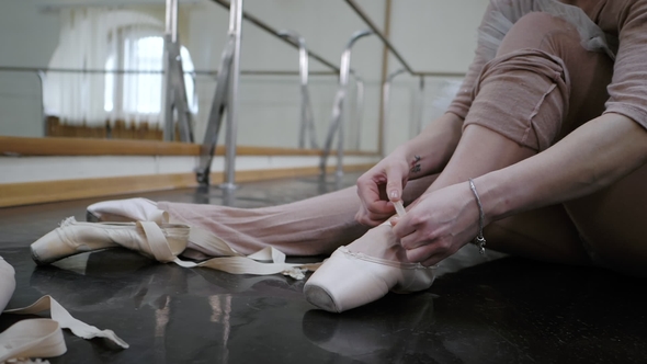 Young Ballerina in Beige Costume Wraps White Silk Ribbons of Her Soft ...