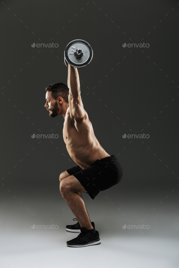 Side view of a strong muscular bodybuilder Stock Photo by vadymvdrobot