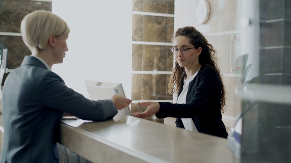 Blonde Businesswoman Talking with Staff at Reception in Hotel and Give ...