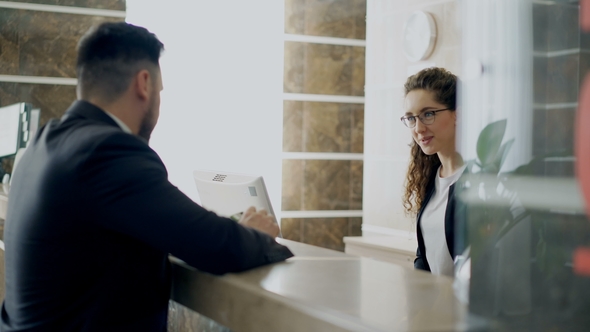 Receptionist Girl Talking with Arrived Businessman About Check-in at ...