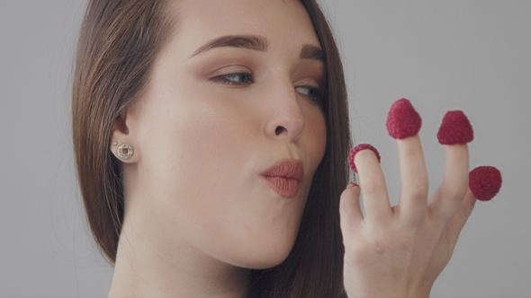 Young Caucasian Woman with Straight Long Hair Eats Raspberry From ...