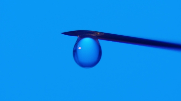 A Drop of Water Gets Bigger on a Tip of a Needle and Falls. A Stream ...