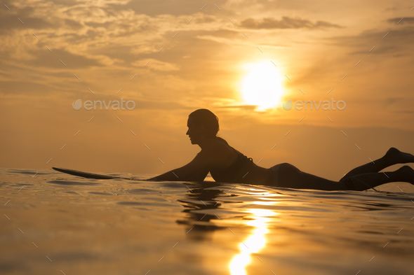 Surfer girl in ocean at sunset time Stock Photo by trubavin | PhotoDune