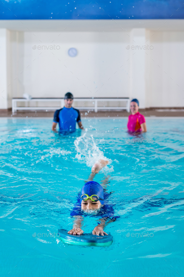 Boy having a swimming lesson with instructor Stock Photo by microgen