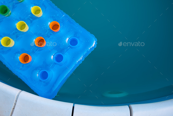 Inflatable mattress floating on swimming pool surface Stock Photo by ...