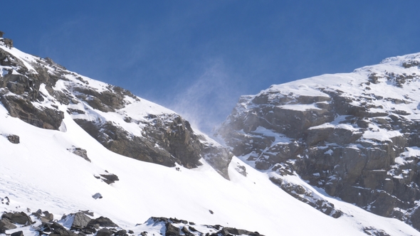 Blowing A Strong Wind Forming Swirls Of Snowflakes On Peaks Of The ...