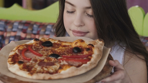 Pretty Young Girl Enjoying the Smell of a Pizza, Stock Footage | VideoHive
