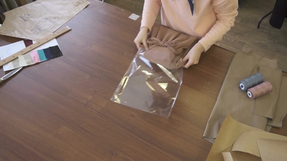 Young Woman Dressmaker Is Packing Clothes, Standing at Table in Sewing ...