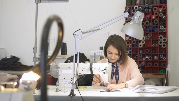 Young Female Seamstress Is Sewing Clothes, Sitting at Table with Sewing ...