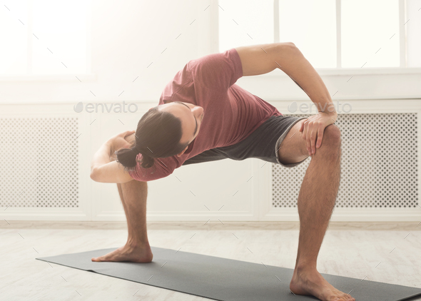Man stretching back and legs at gym Stock Photo by Prostock-studio