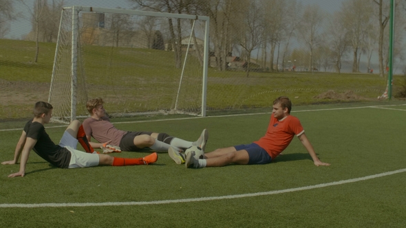 Footballers Relaxing on Soccer Field After Game, Stock Footage | VideoHive