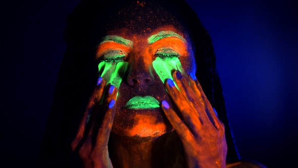 Portrait of Girl Smears and Rubs Fluorescent Paint Under Eyes. Dye ...