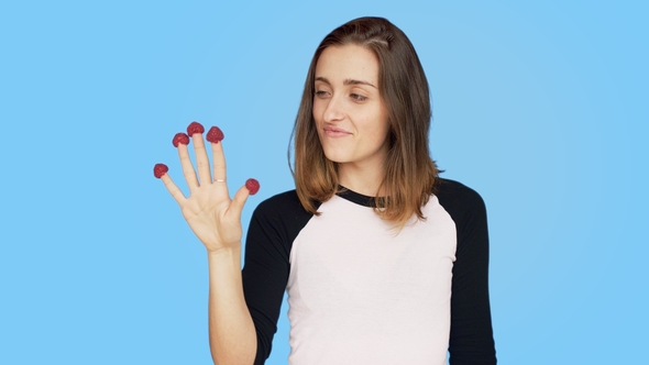 Pretty Young Woman Eats Raspberries From Fingers, Stock Footage | VideoHive