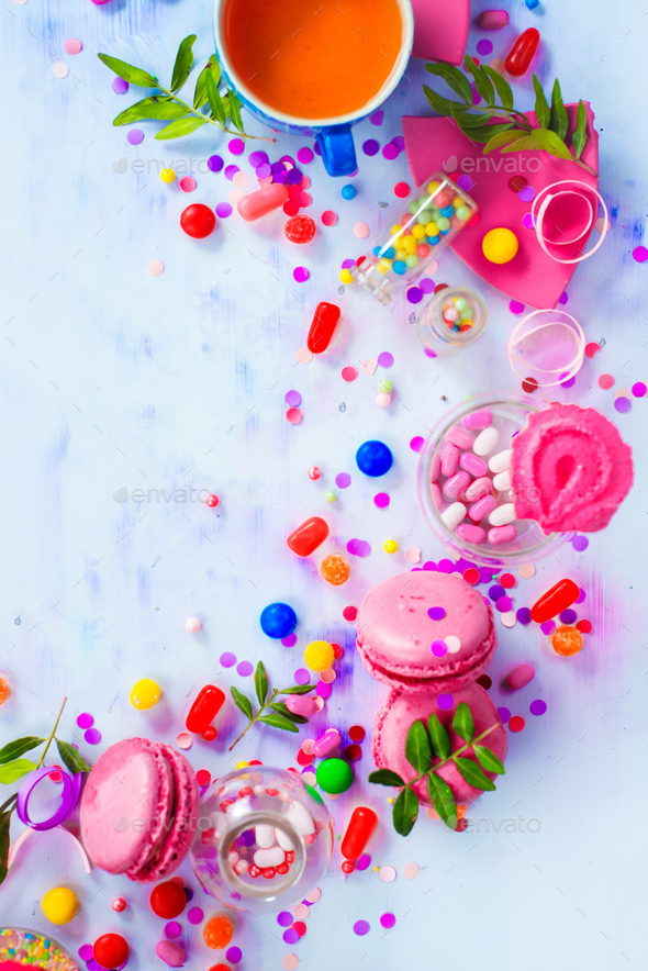 Pink macarons, candies, confetti and sprinkles in a creative party ...