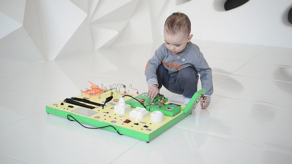 Little Baby Boy Intently Playing with Busy Board, Stock Footage | VideoHive