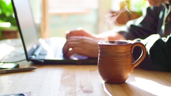 Hot Tea Near a Man Using Laptop, Stock Footage | VideoHive
