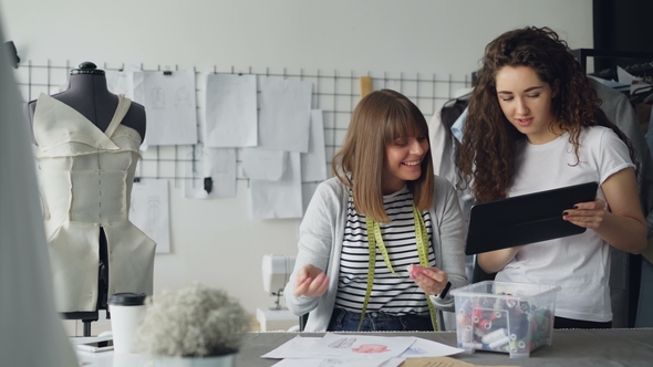 Young Clothing Design Entrepreneurs Are Watching Tablet and Choosing ...