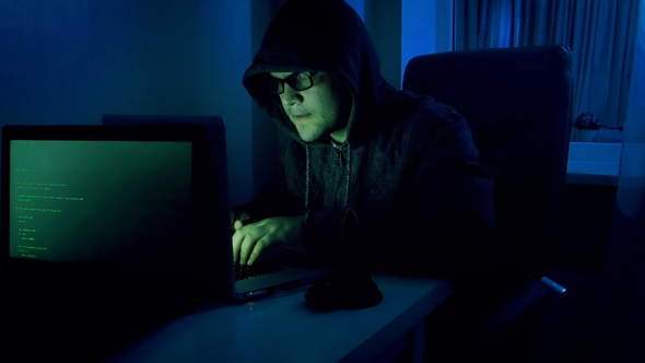 Young Male Pretends To Be Hacker. Geeky Man in Hood Working on Laptop ...