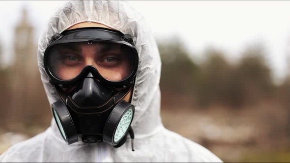 Man in Bio-hazard Suit and Gas Mask Looks Straight Into the Camera ...