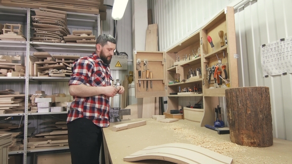 Man Carpenter in a Shirt with a Beard Uses Tools in the Workshop, Stock ...