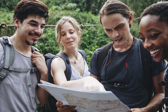 Group of friends looking at a map together travel and teamwork concept ...