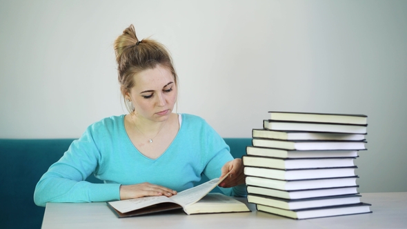 Girl Student Chooses a Phone, Pushing a Stack of Books on the Table ...