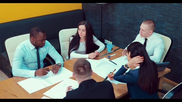 Group of Multiethnic Architects Studying a Construction Plan in a ...